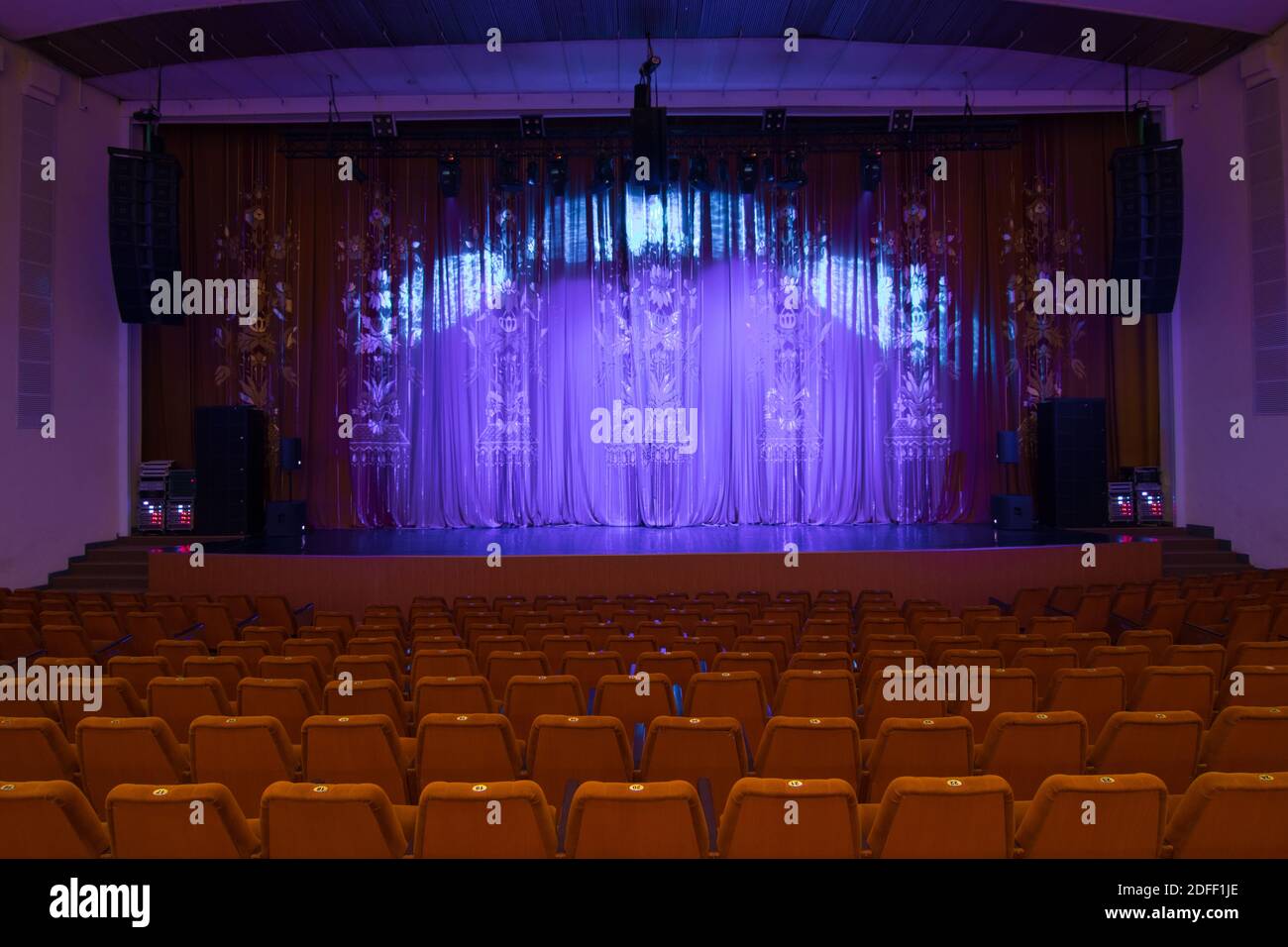 Interior of a concert hall or theater with light and velvet chairs ...