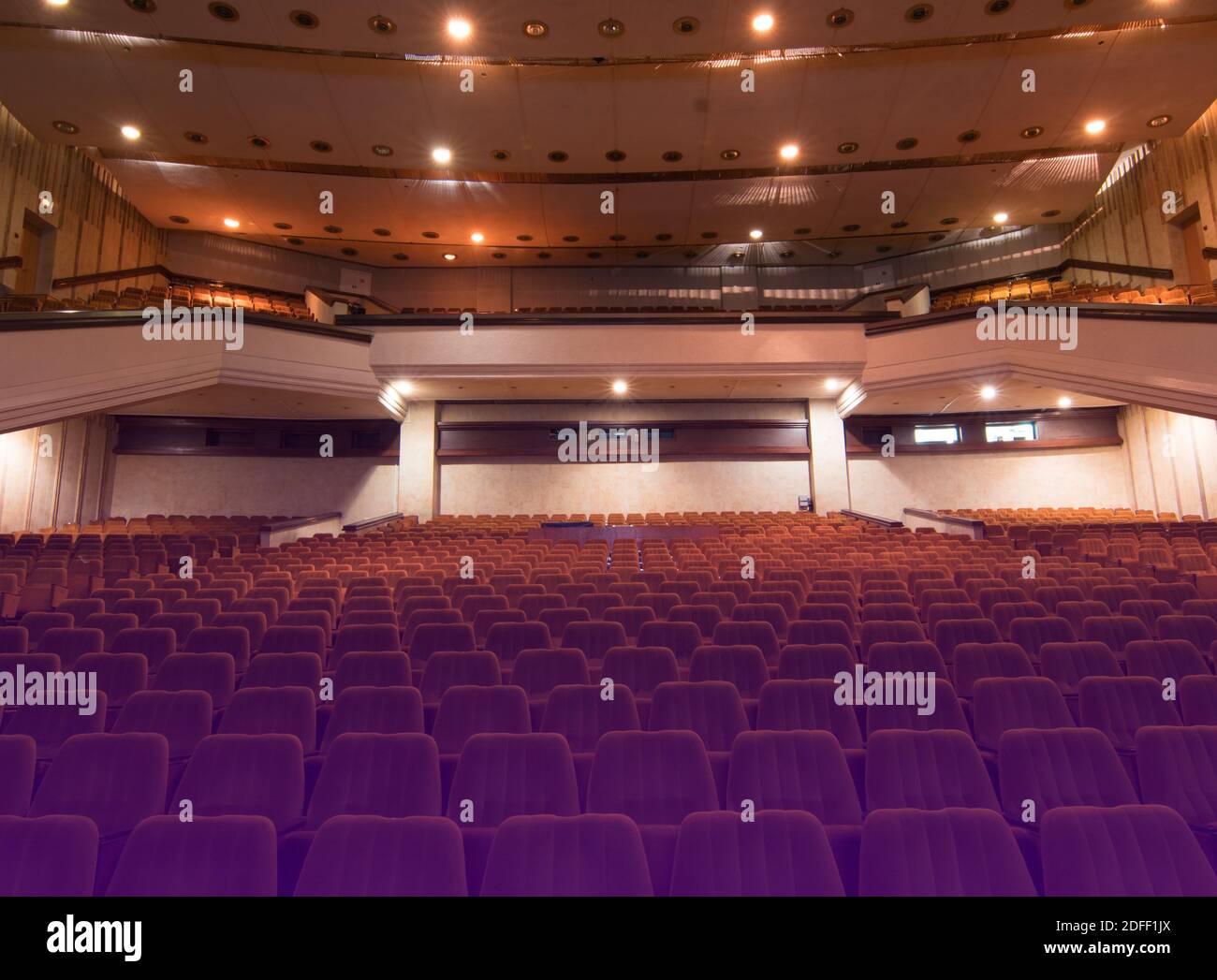 Interior of a concert hall or theater with light and velvet chairs ...