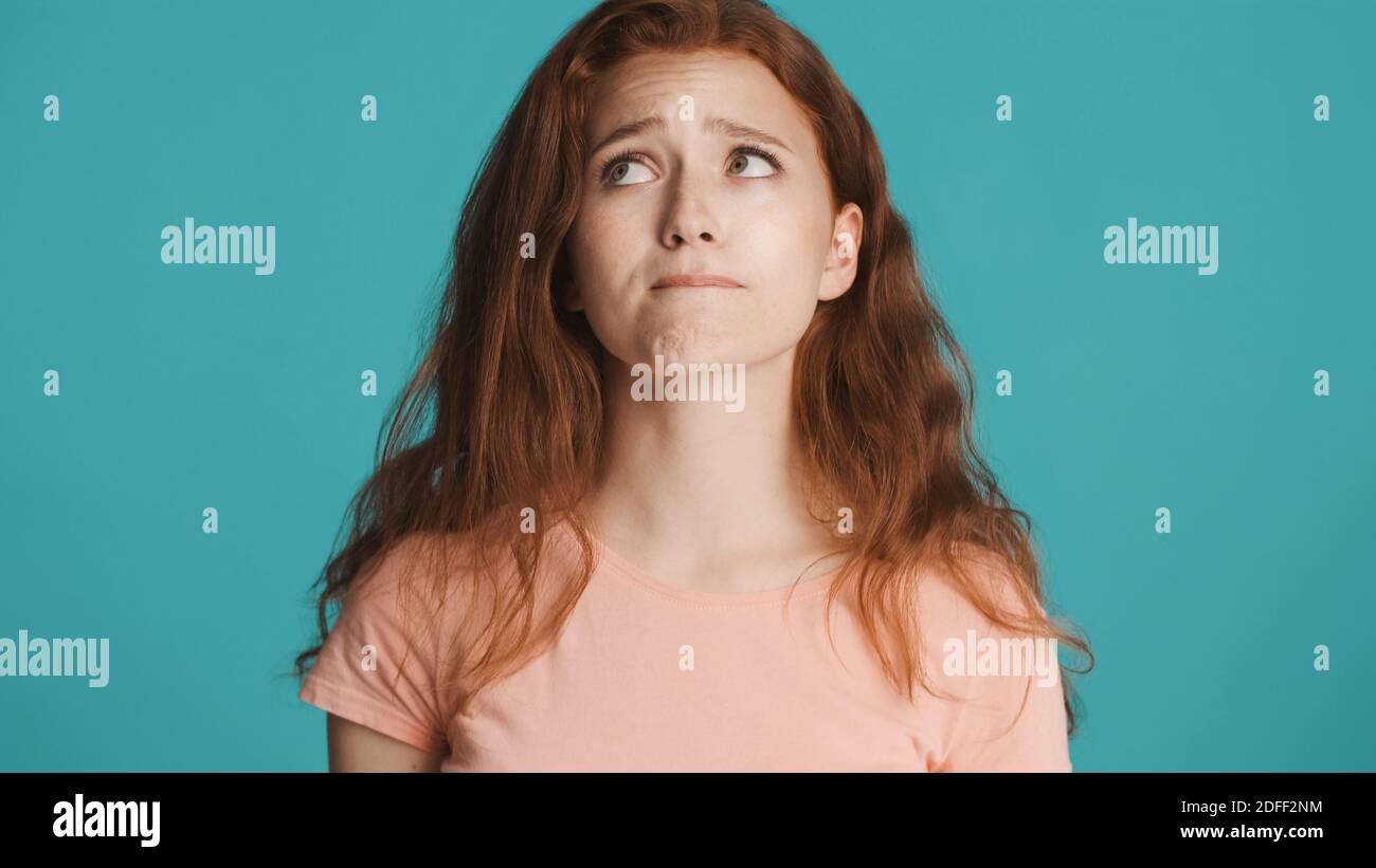 Attractive anxious girl nervously biting lips posing on camera over ...