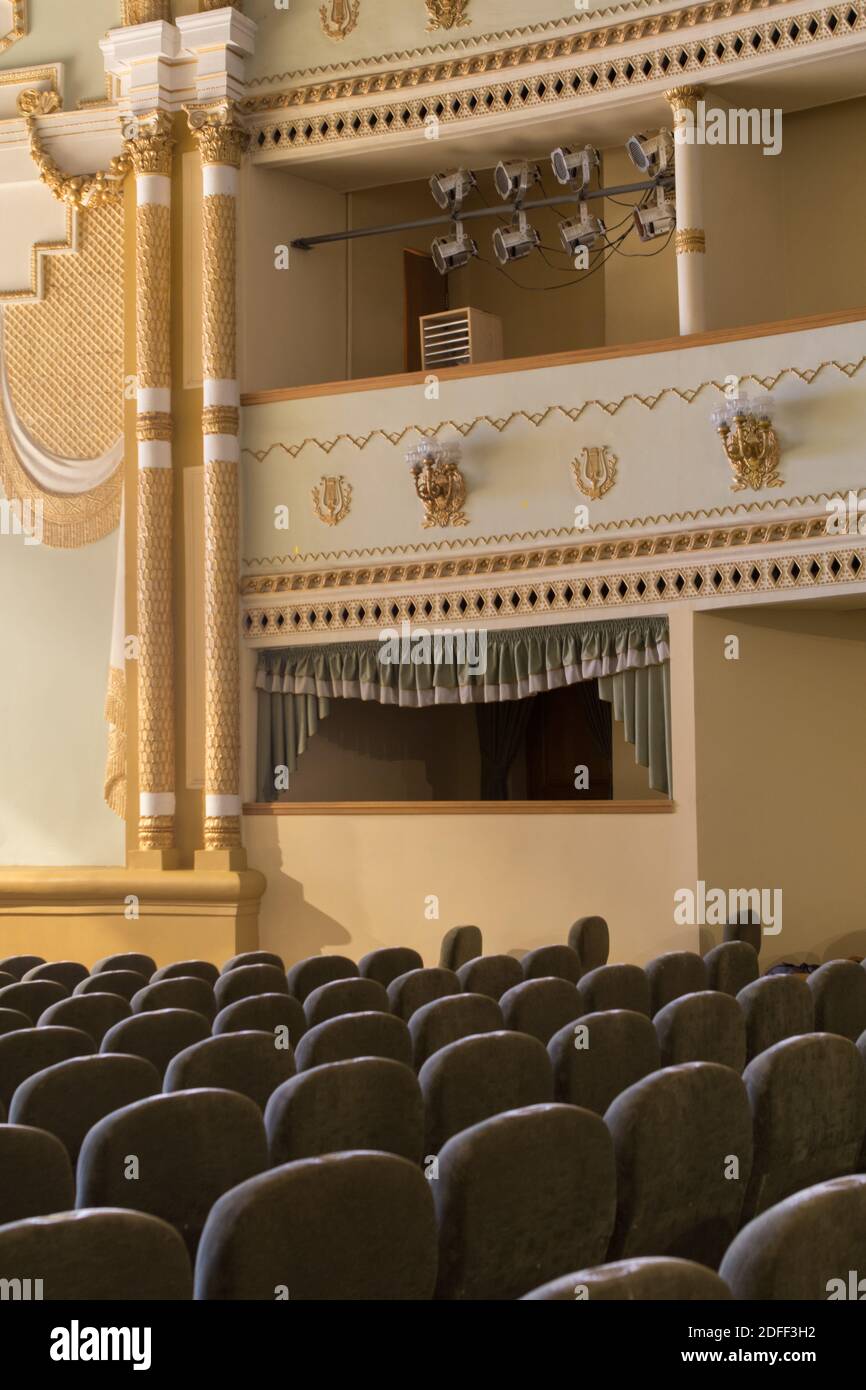 Interior of a concert hall or theater with light and velvet chairs ...
