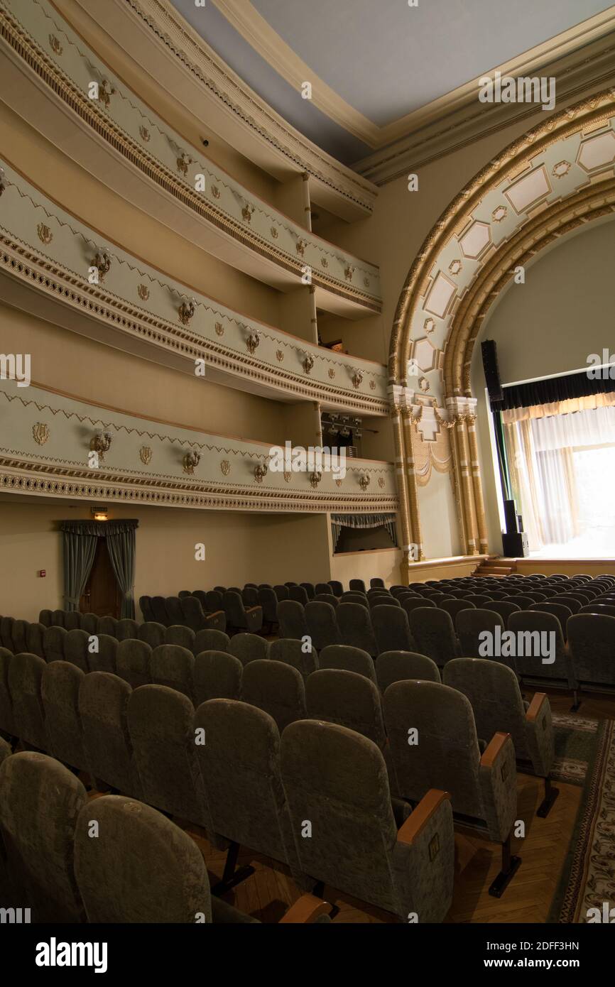 Interior of a concert hall or theater with light and velvet chairs ...