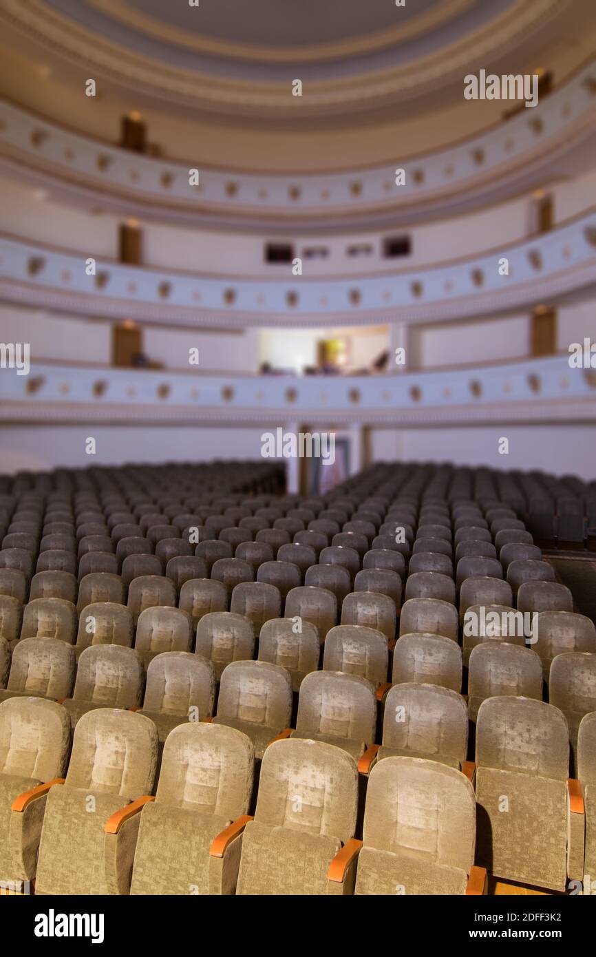 Interior of a concert hall or theater with light and velvet chairs ...
