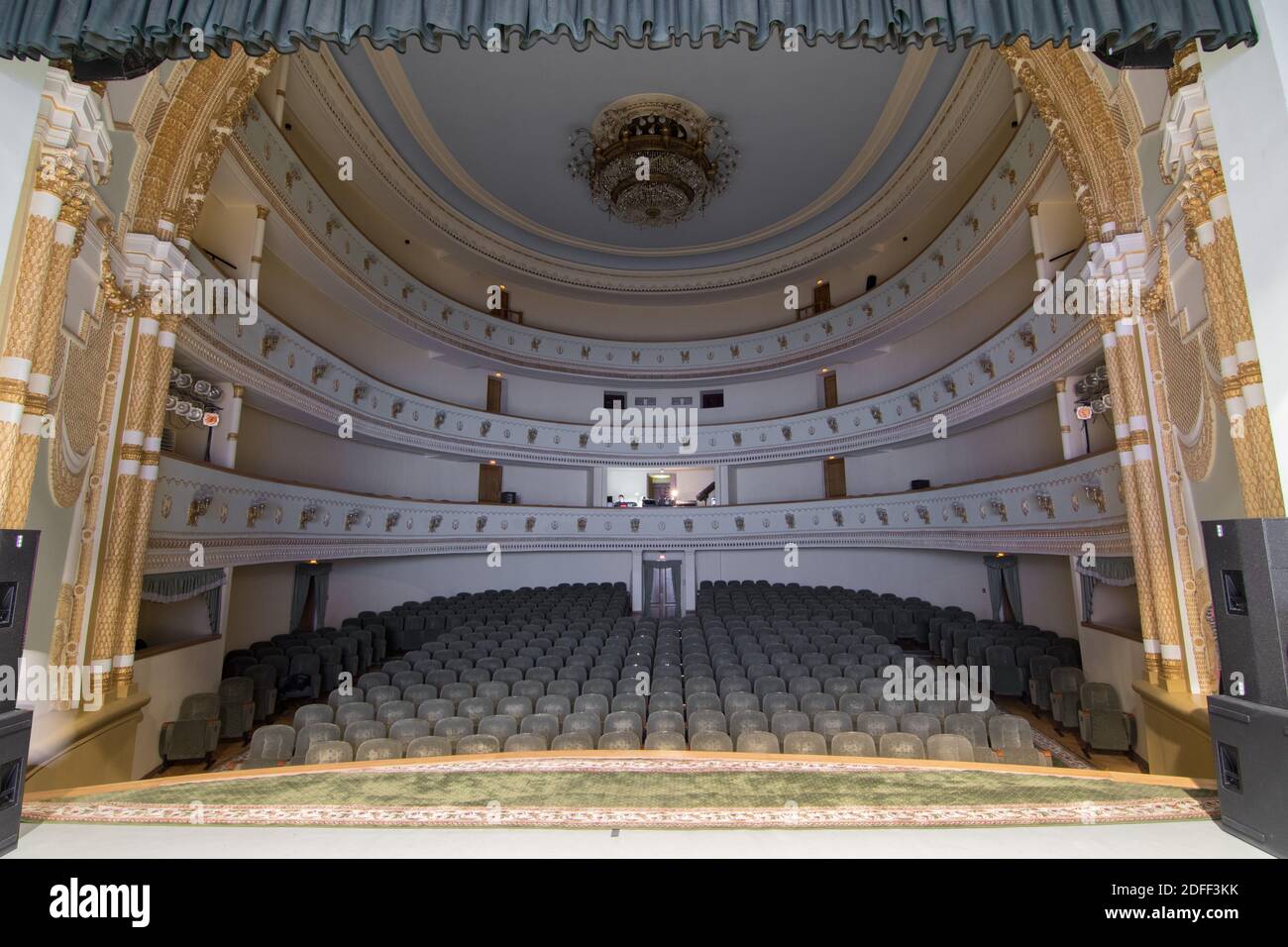 Interior of a concert hall or theater with light and velvet chairs ...