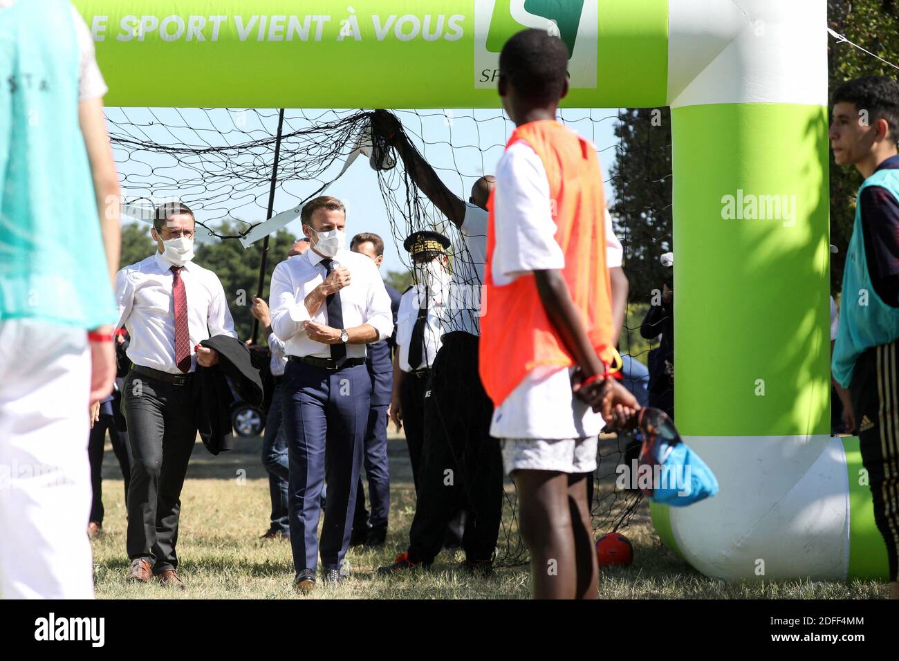 President Emmanuel Macron plays football with youth taking part in a ...