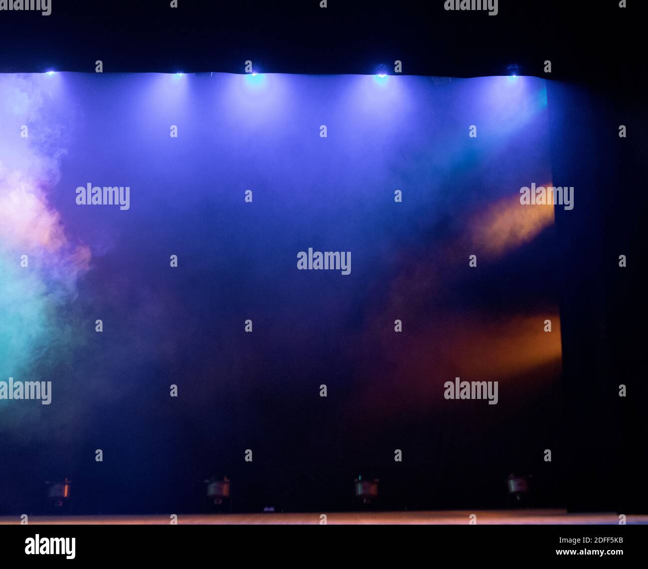 An empty stage of the theater, lit by spotlights and smoke before the ...