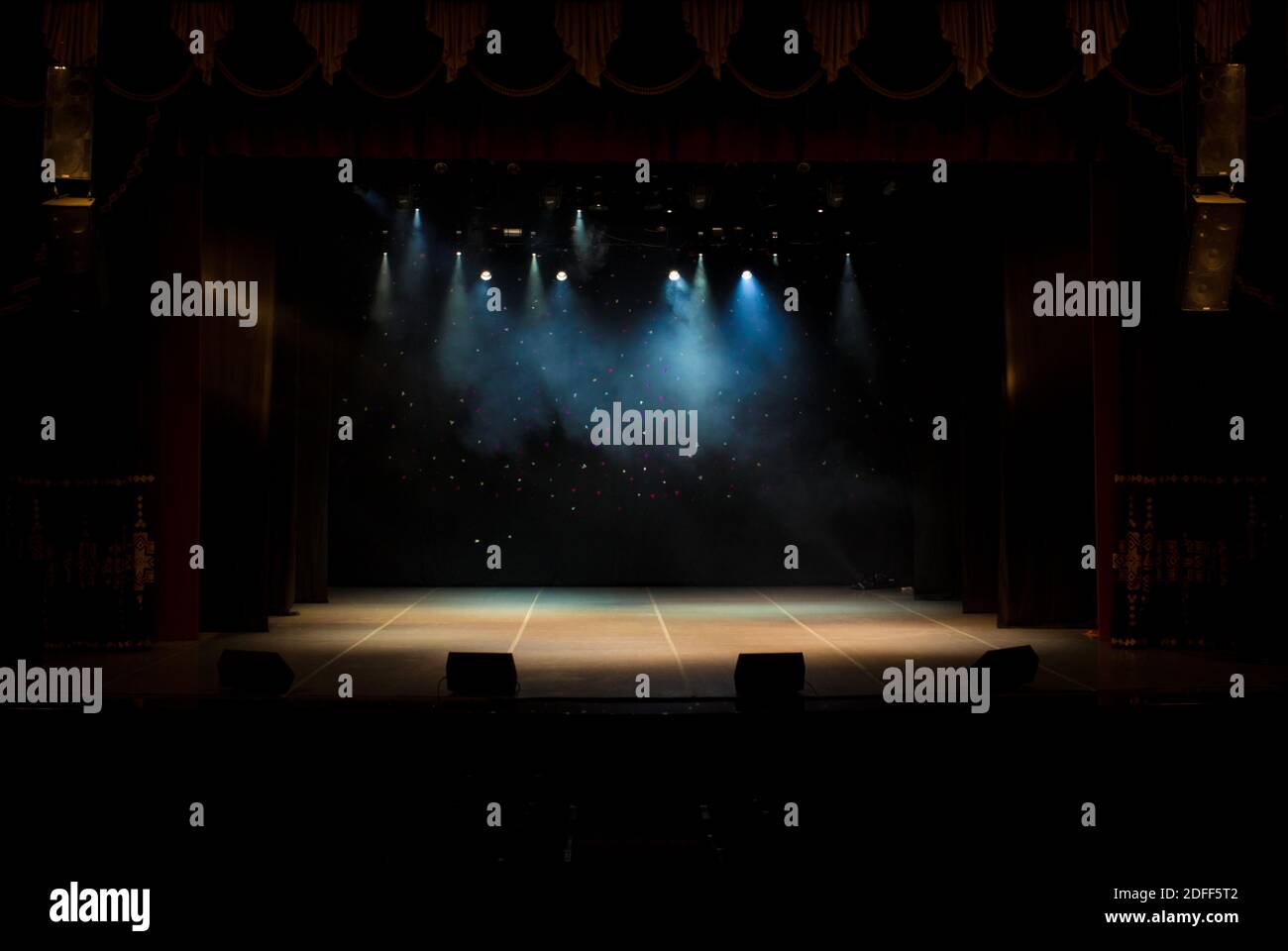 An empty stage of the theater, lit by spotlights and smoke before the ...