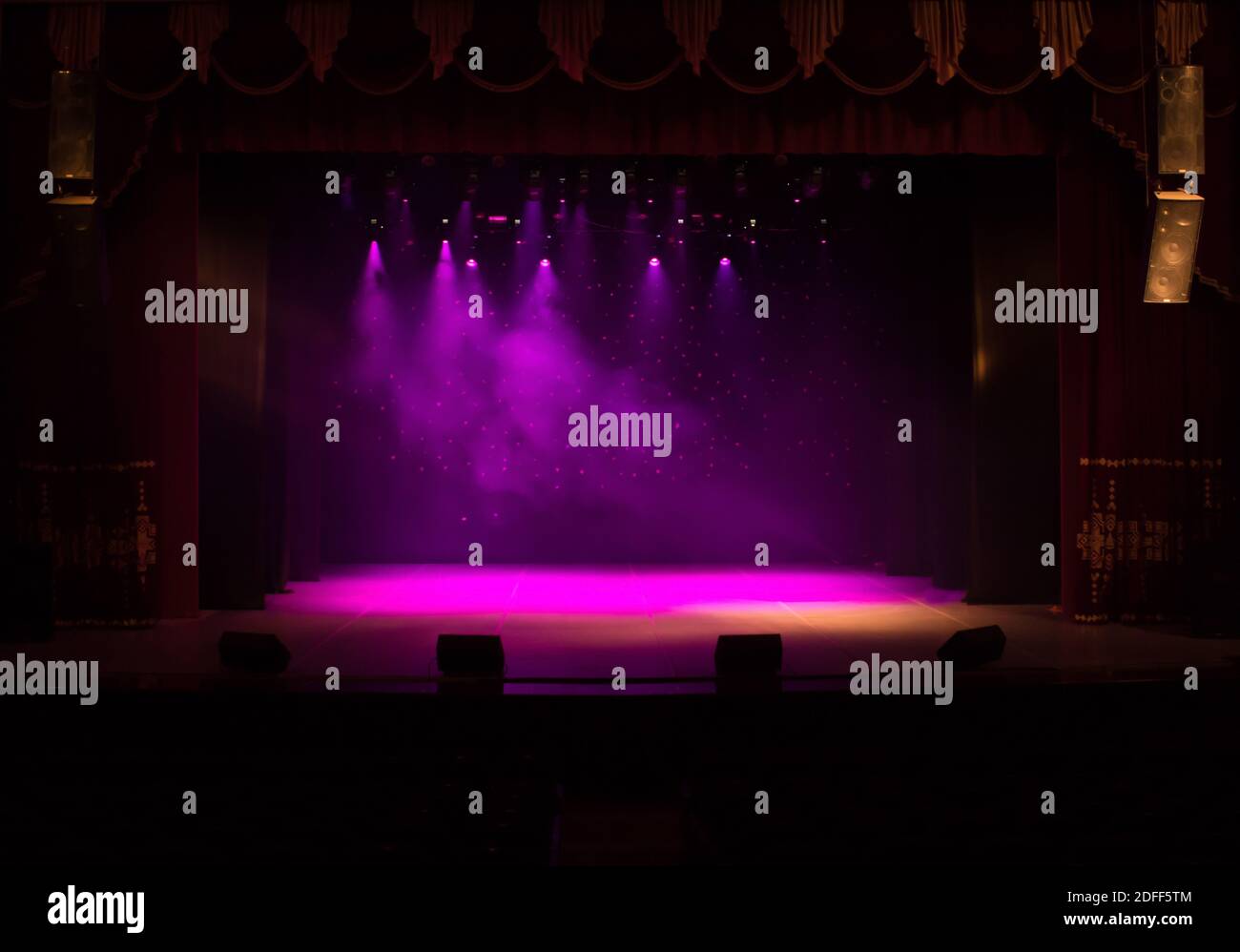 An empty stage of the theater, lit by spotlights and smoke before the ...