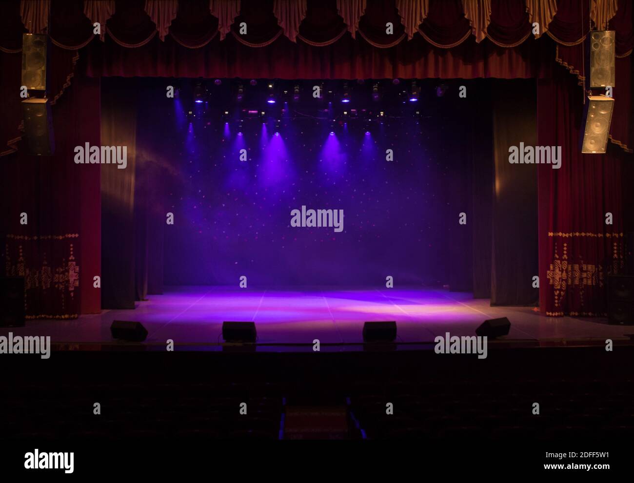 An empty stage of the theater, lit by spotlights and smoke before the ...