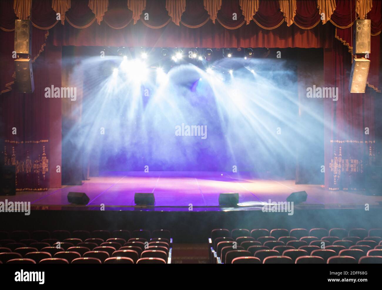 An empty stage of the theater, lit by spotlights and smoke before the ...