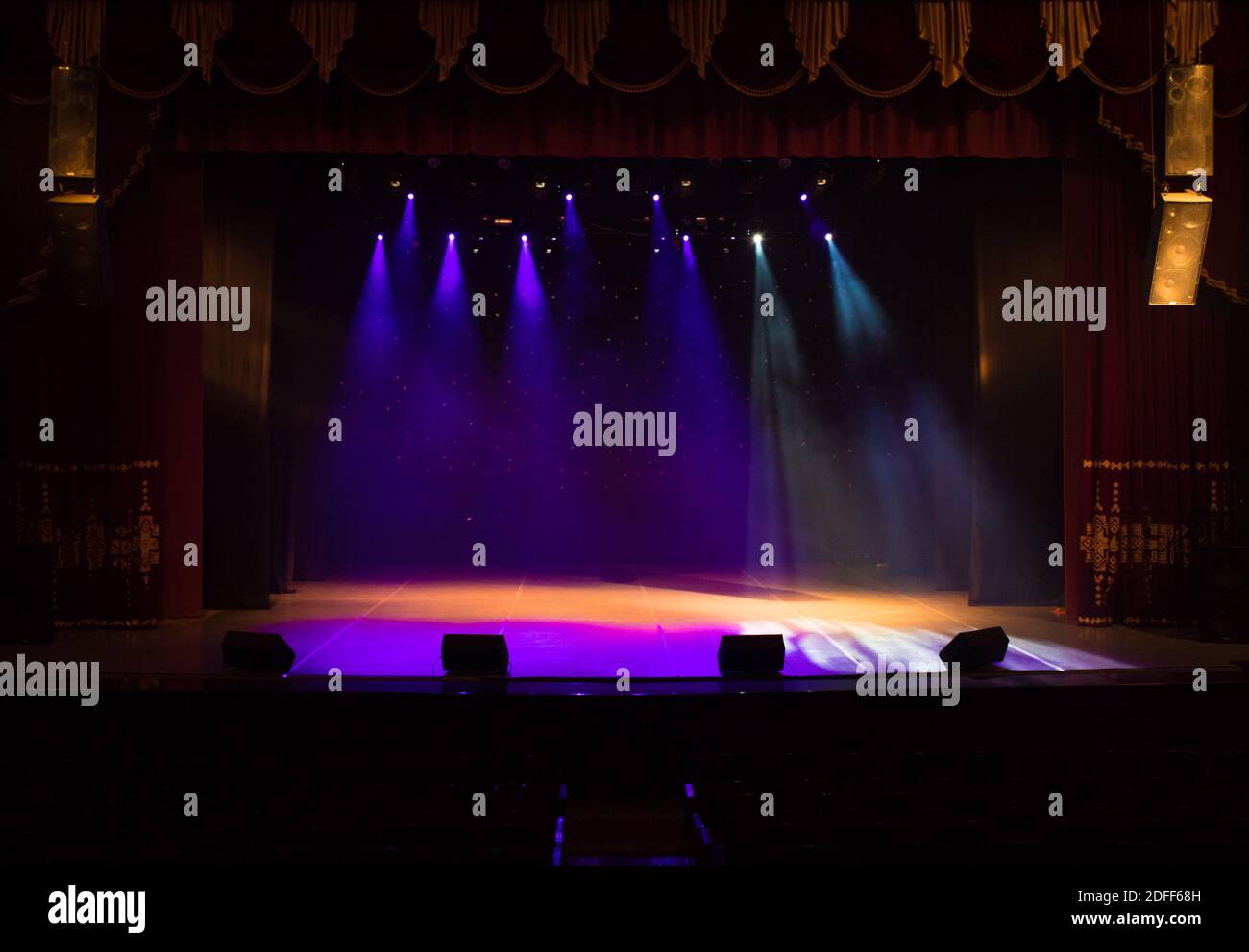 An empty stage of the theater, lit by spotlights and smoke before the ...