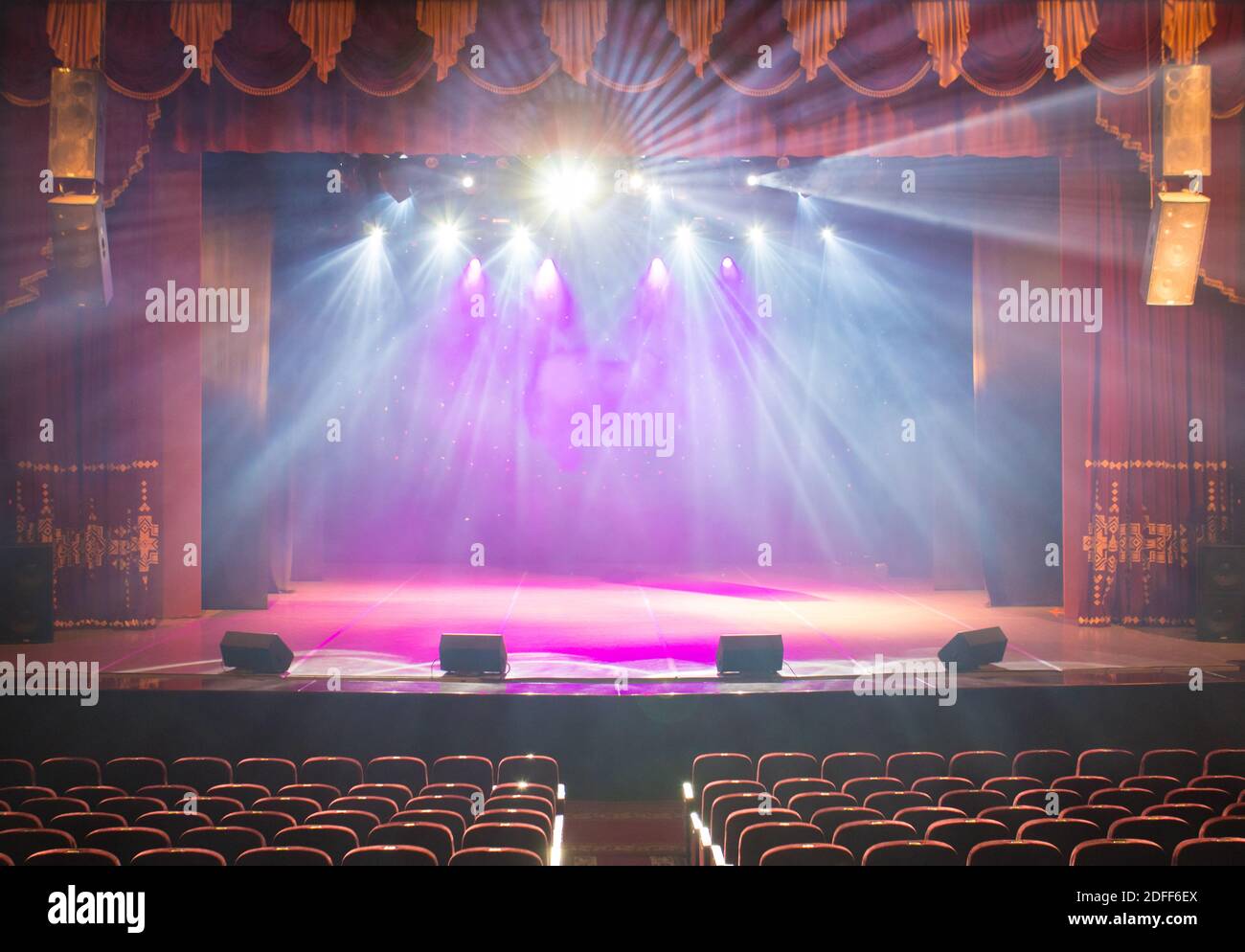 An empty stage of the theater, lit by spotlights and smoke before the ...