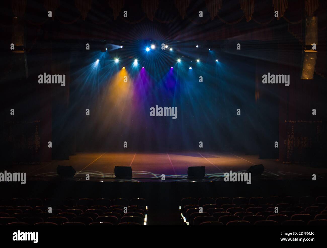 An empty stage of the theater, lit by spotlights and smoke before the ...