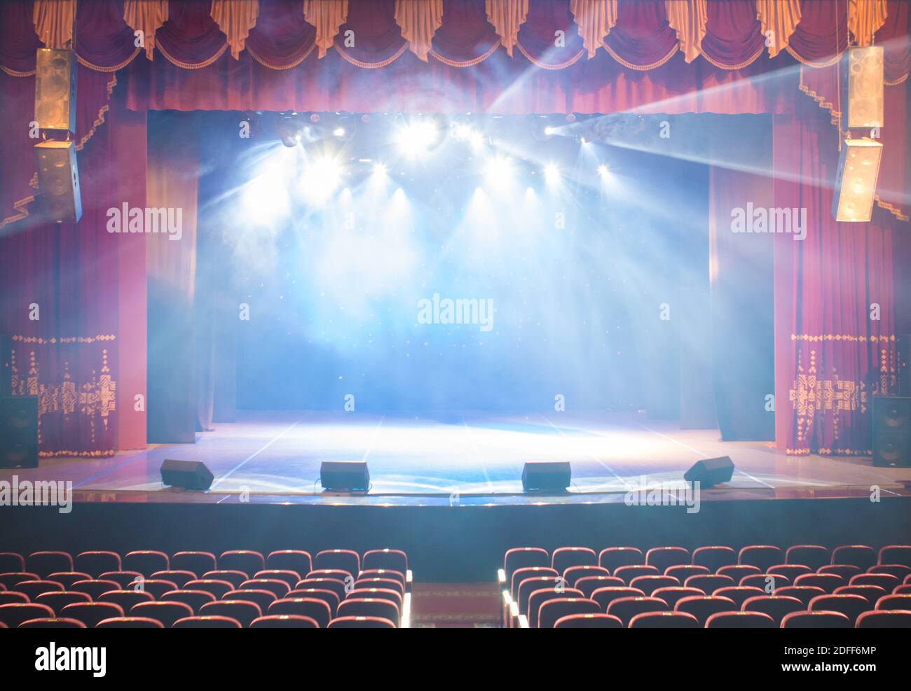 An empty stage of the theater, lit by spotlights and smoke before the ...