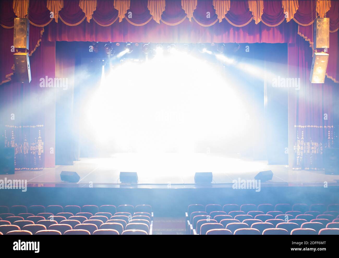 An empty stage of the theater, lit by spotlights and smoke before the ...