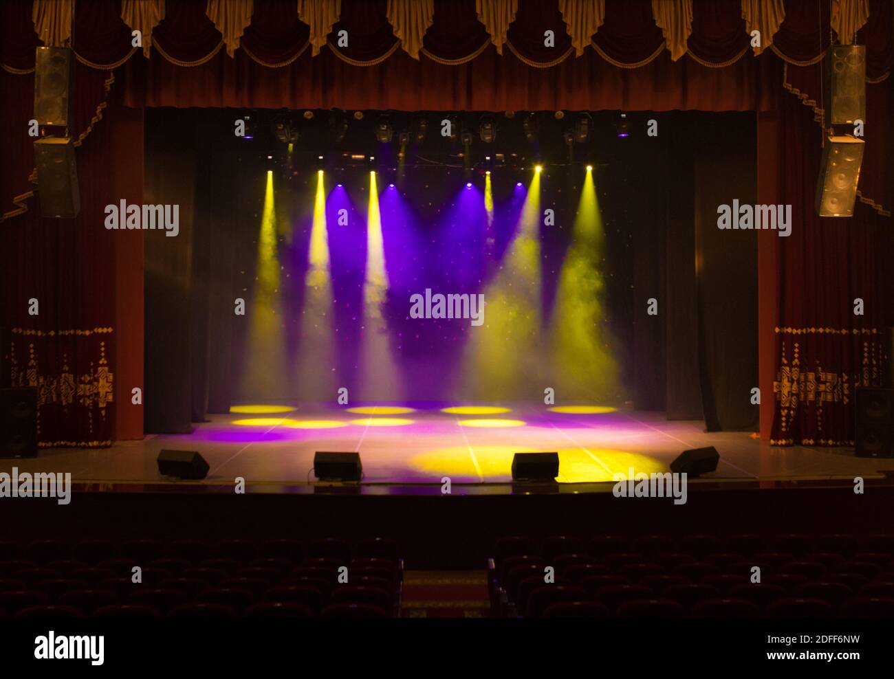 An empty stage of the theater, lit by spotlights and smoke before the ...