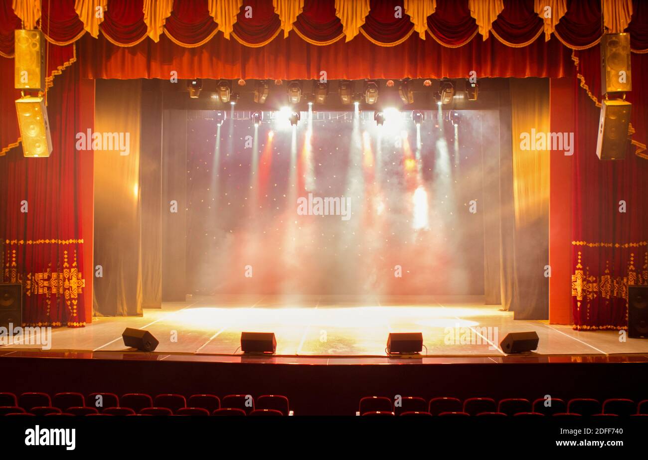 An empty stage of the theater, lit by spotlights and smoke before the ...