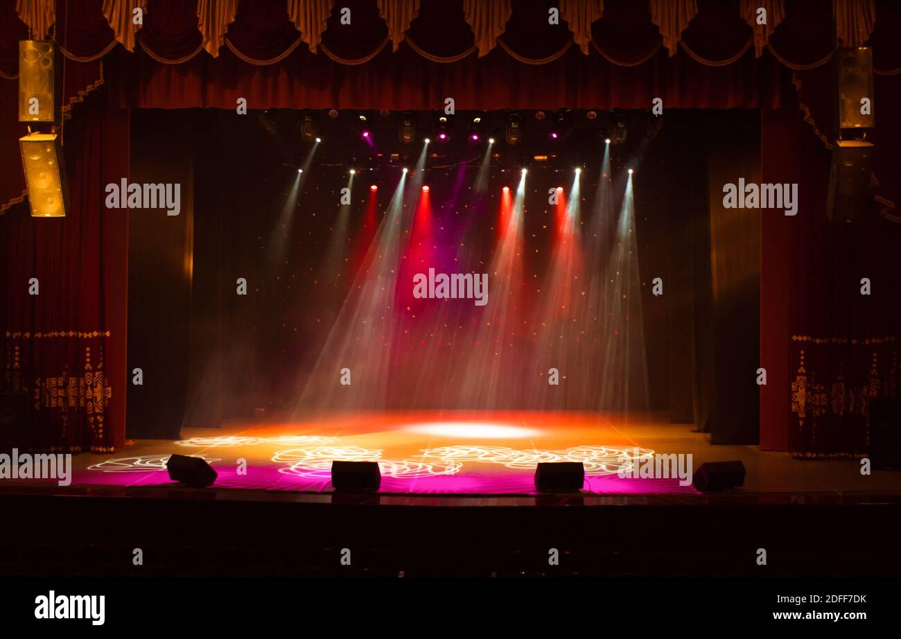 An empty stage of the theater, lit by spotlights and smoke before the ...
