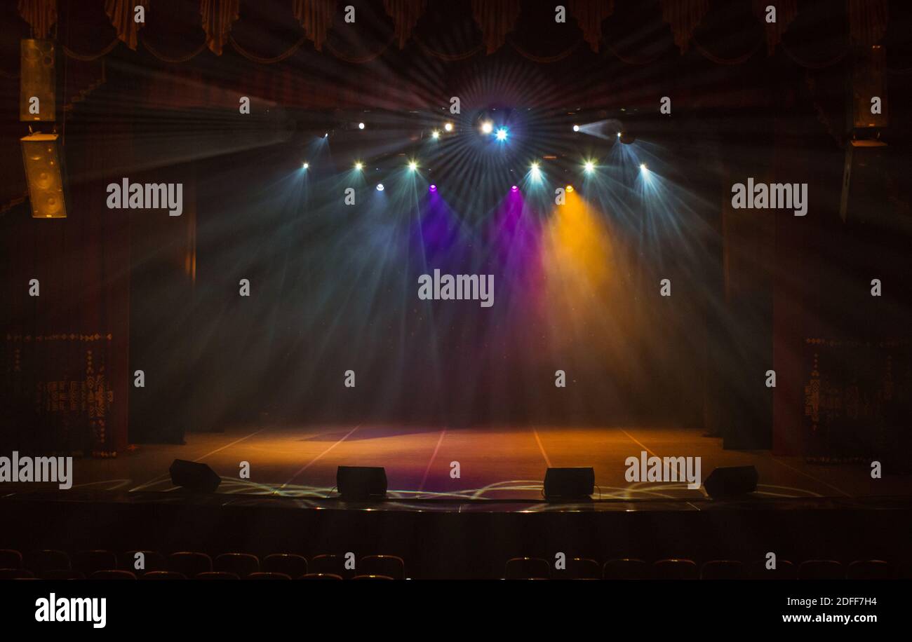 An empty stage of the theater, lit by spotlights and smoke before the ...