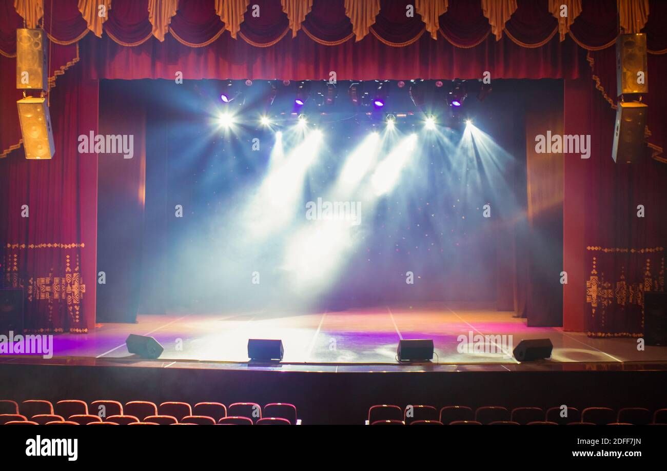 An empty stage of the theater, lit by spotlights and smoke before the ...
