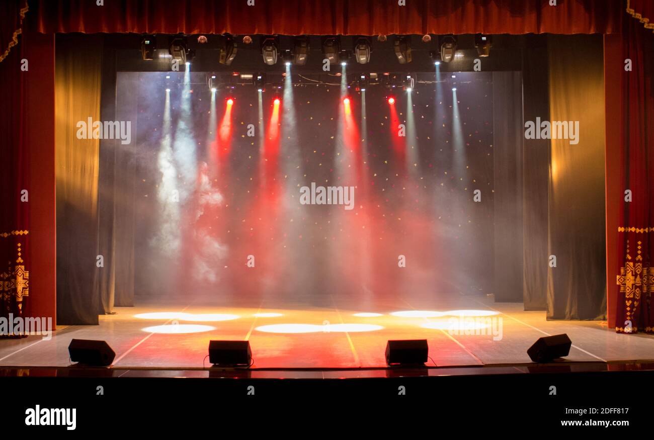 An empty stage of the theater, lit by spotlights and smoke before the ...