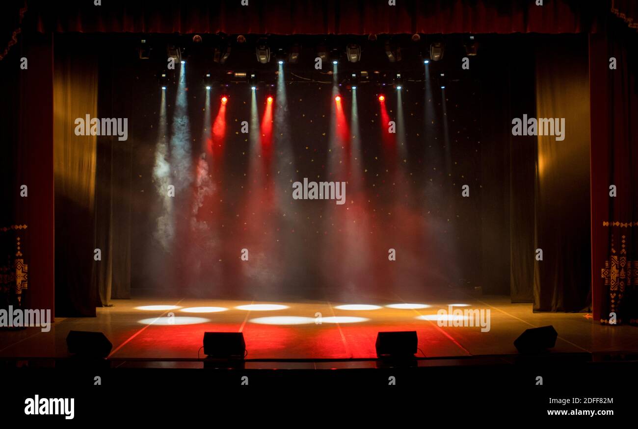 An empty stage of the theater, lit by spotlights and smoke before the ...