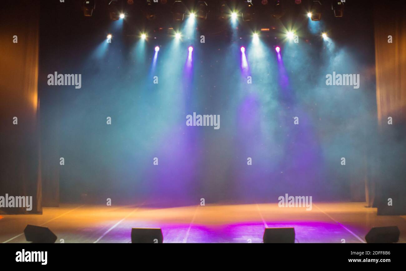 An empty stage of the theater, lit by spotlights and smoke before the ...