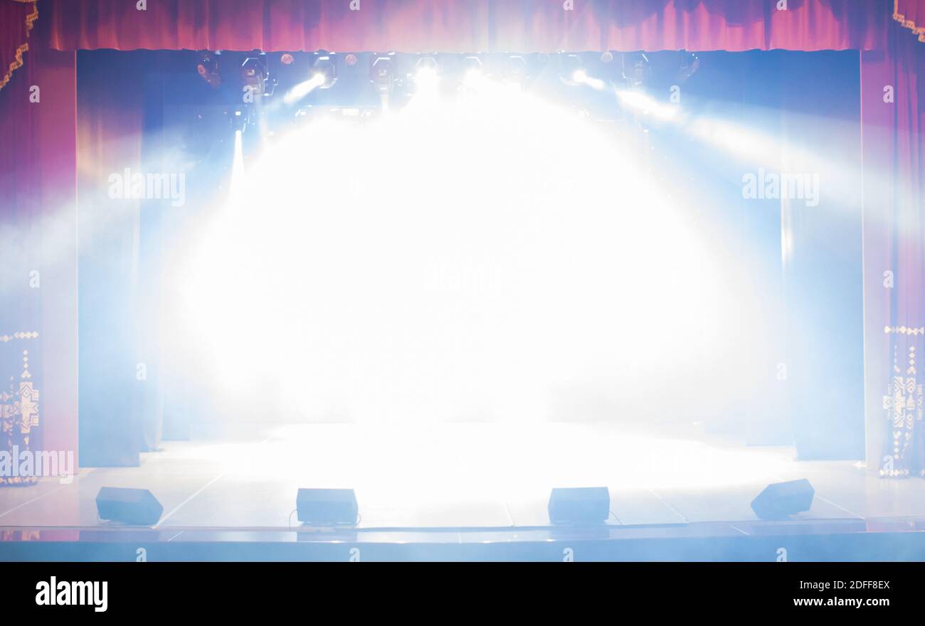 An empty stage of the theater, lit by spotlights and smoke before the ...