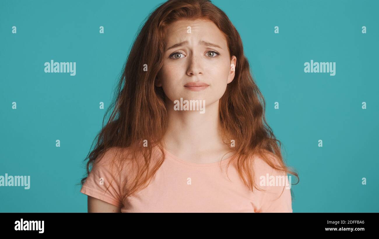 Upset girl guiltily looking in camera over colorful background Stock ...