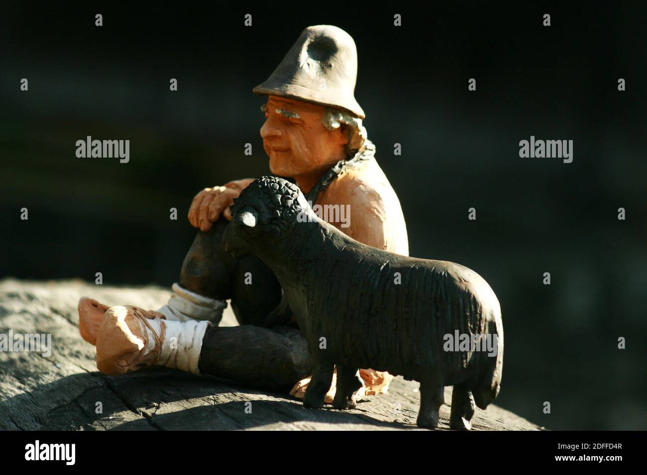 Close-up of a realistic clay sculpture depicting a peasant with a sheep ...