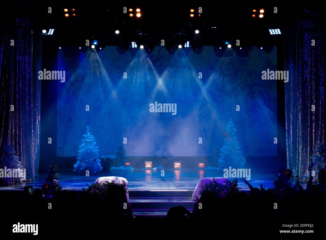A theater stage with a curtain illuminated by stage light and smoke ...