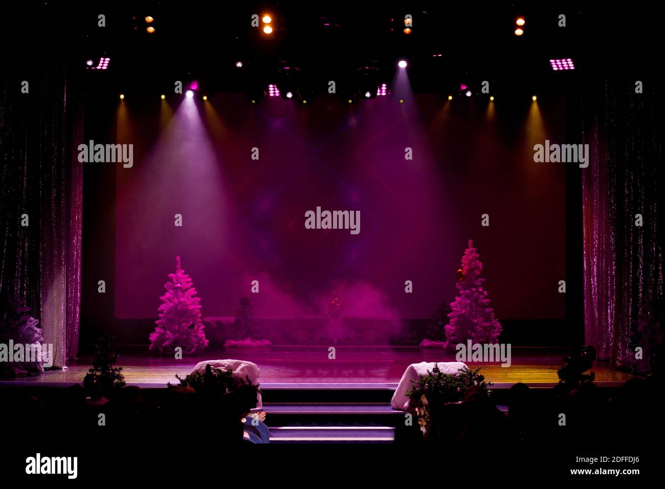 A theater stage with a curtain illuminated by stage light and smoke ...
