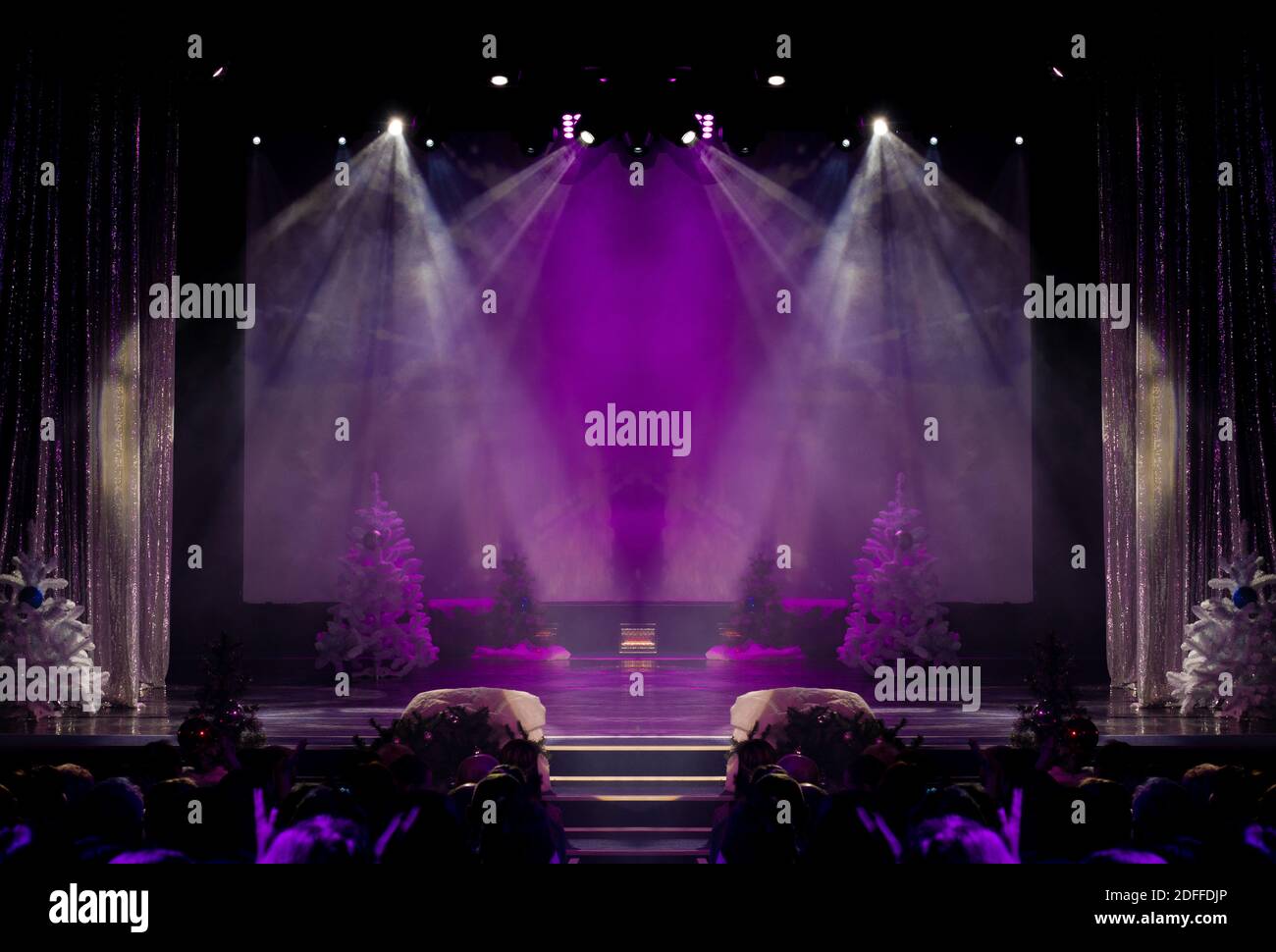A theater stage with a curtain illuminated by stage light and smoke ...
