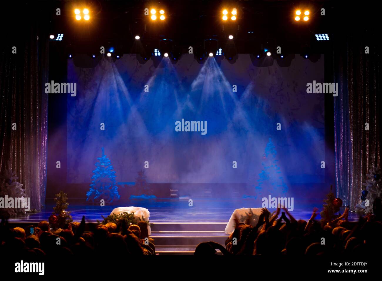 A theater stage with a curtain illuminated by stage light and smoke ...