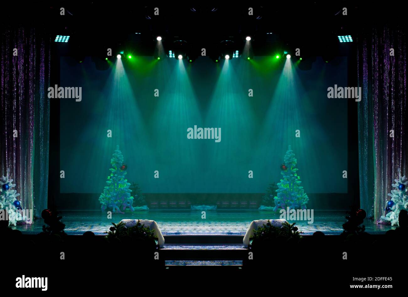 A theater stage with a curtain illuminated by stage light and smoke ...