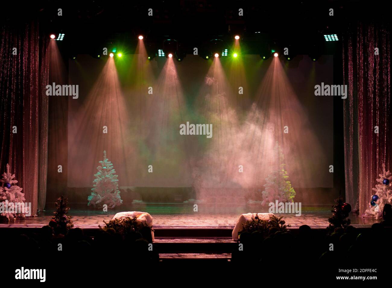 A theater stage with a curtain illuminated by stage light and smoke ...