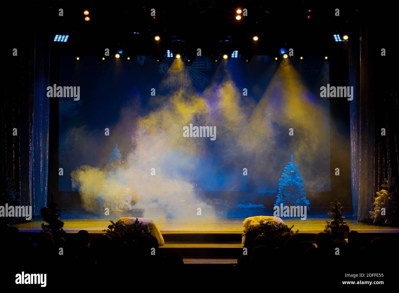 A theater stage with a curtain illuminated by stage light and smoke ...