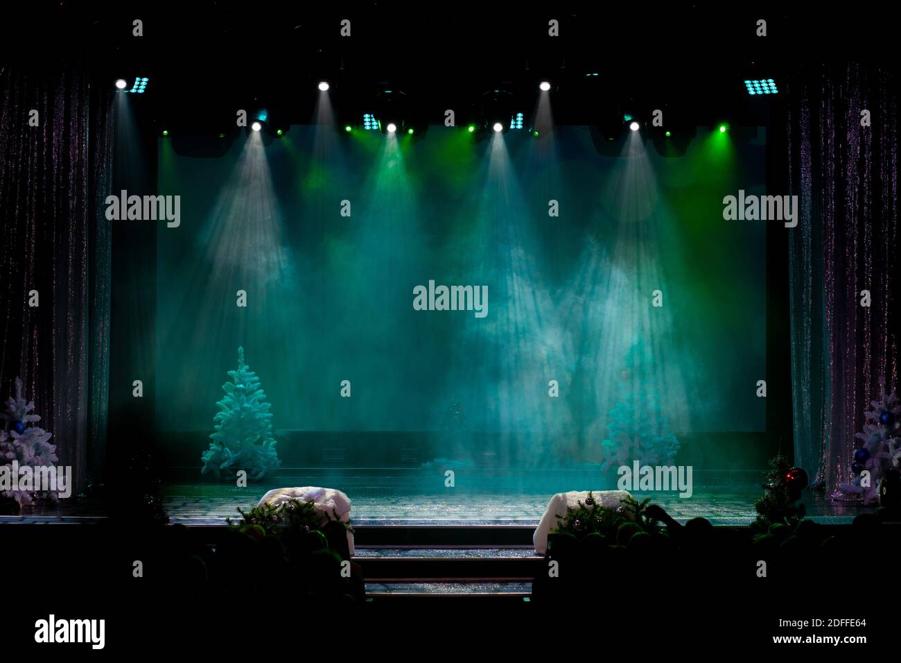 A theater stage with a curtain illuminated by stage light and smoke ...