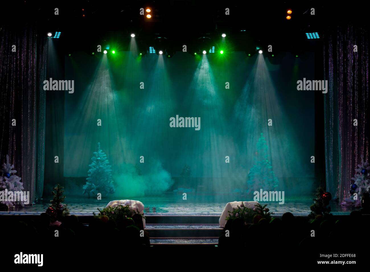 A theater stage with a curtain illuminated by stage light and smoke ...