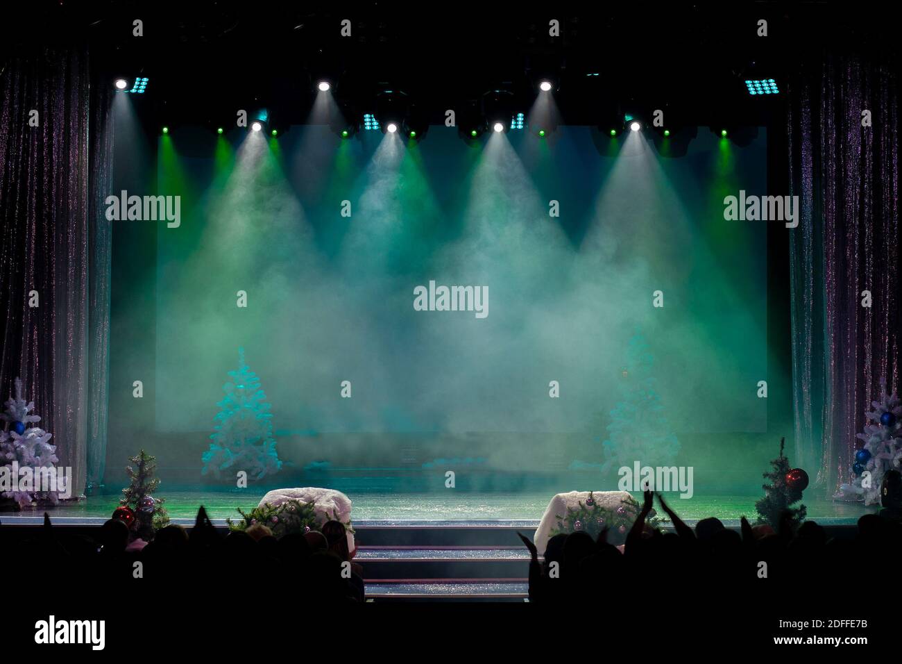 A theater stage with a curtain illuminated by stage light and smoke ...