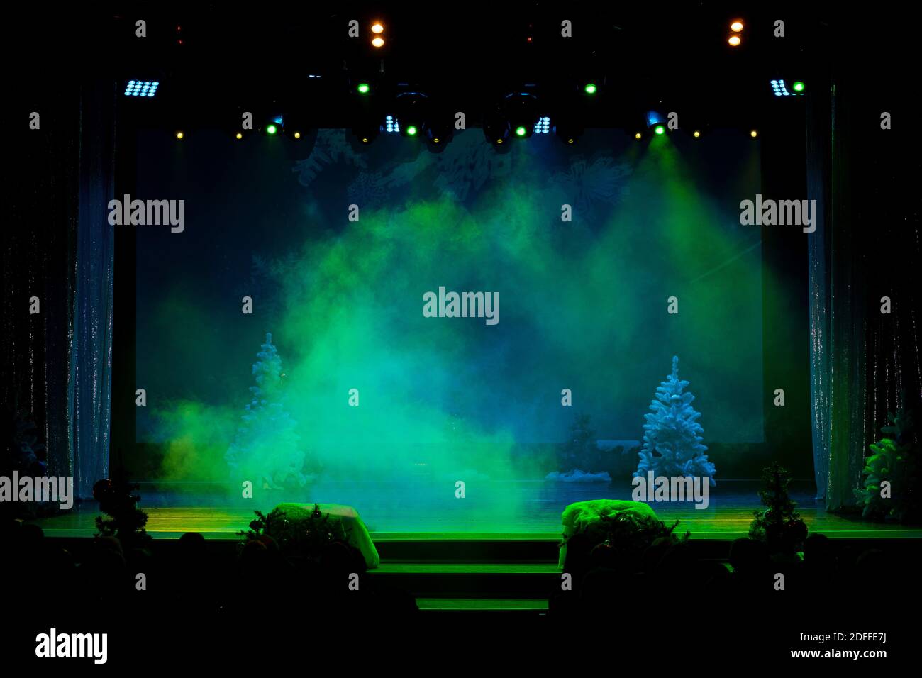 A theater stage with a curtain illuminated by stage light and smoke ...