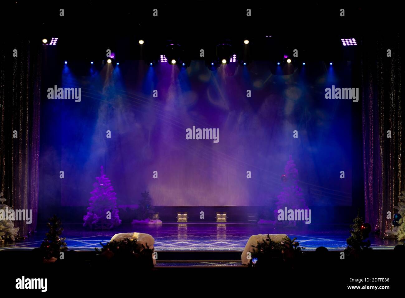 A theater stage with a curtain illuminated by stage light and smoke ...