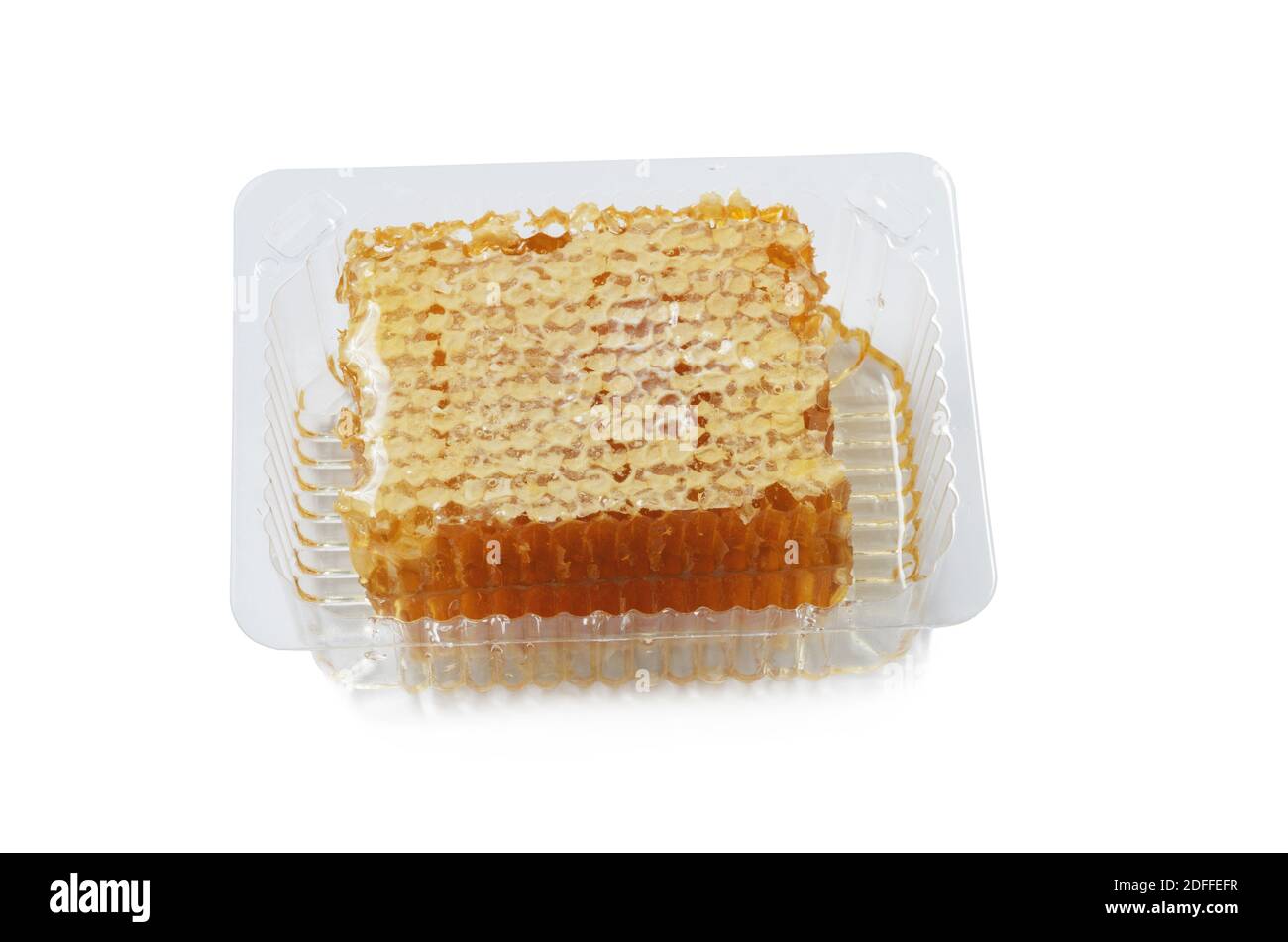 Honey in a honeycomb Packed in a plastic disposable container isolated ...