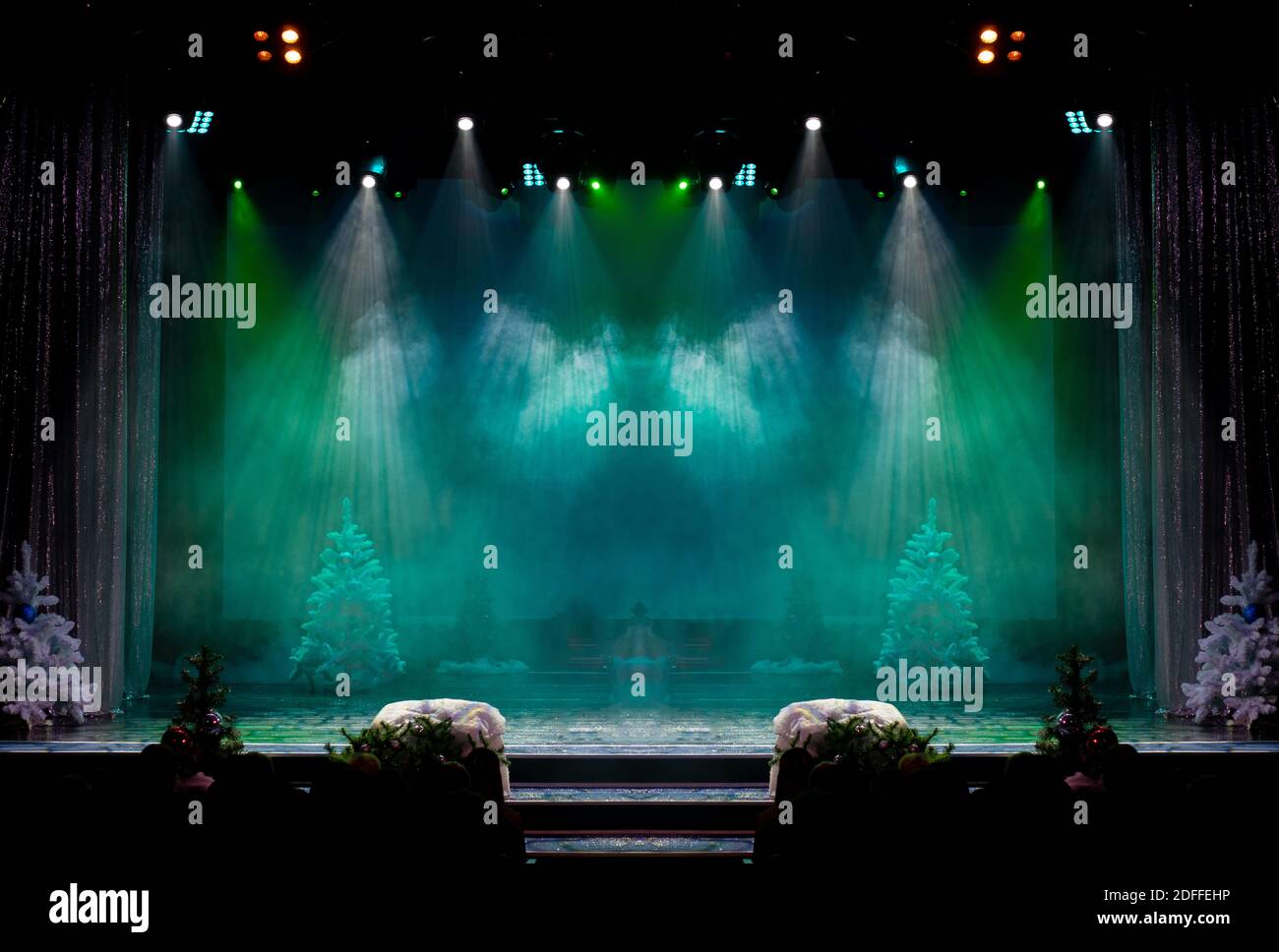 A theater stage with a curtain illuminated by stage light and smoke ...