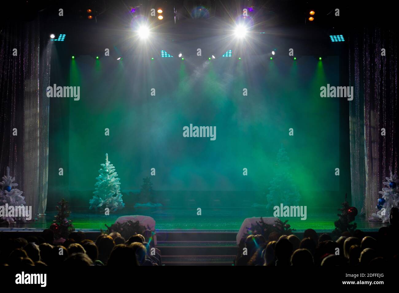 A theater stage with a curtain illuminated by stage light and smoke ...