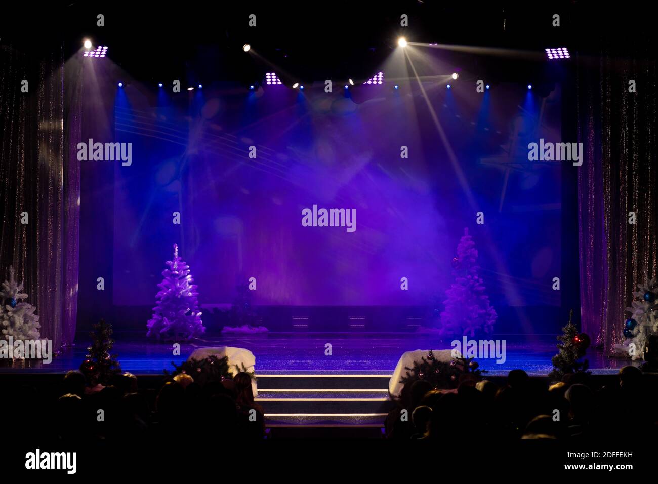 A theater stage with a curtain illuminated by stage light and smoke ...