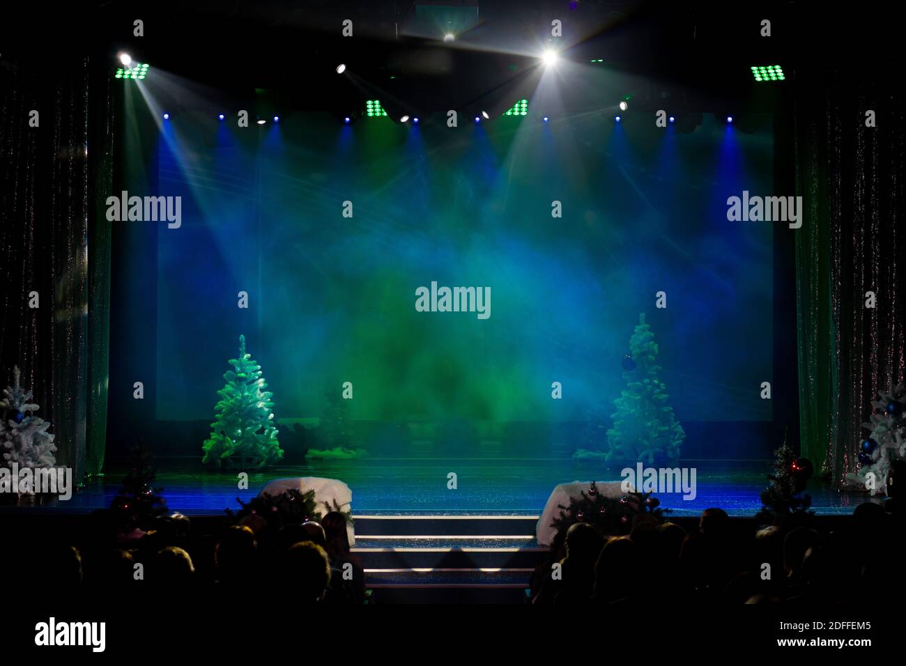 A theater stage with a curtain illuminated by stage light and smoke ...