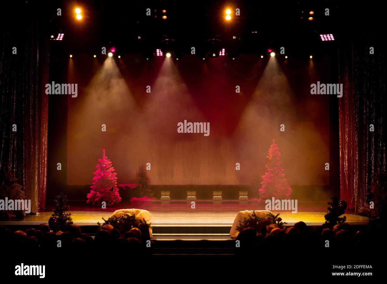 A theater stage with a curtain illuminated by stage light and smoke ...