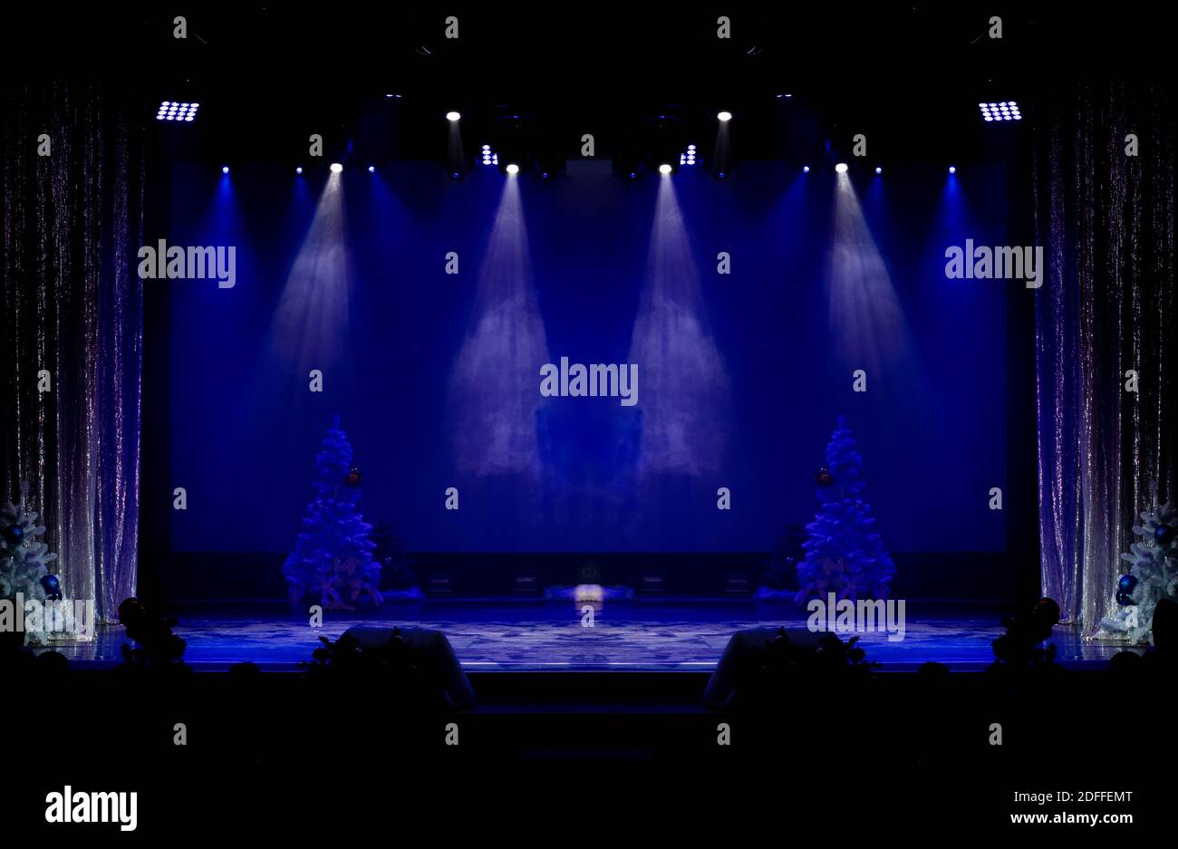 A theater stage with a curtain illuminated by stage light and smoke ...