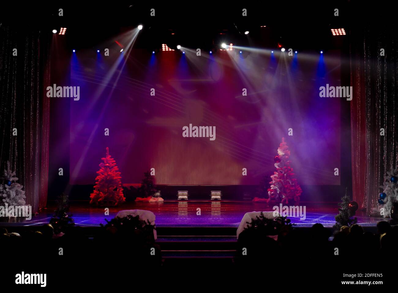 A theater stage with a curtain illuminated by stage light and smoke ...