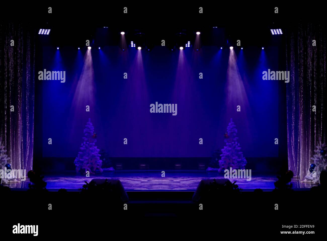 A theater stage with a curtain illuminated by stage light and smoke ...